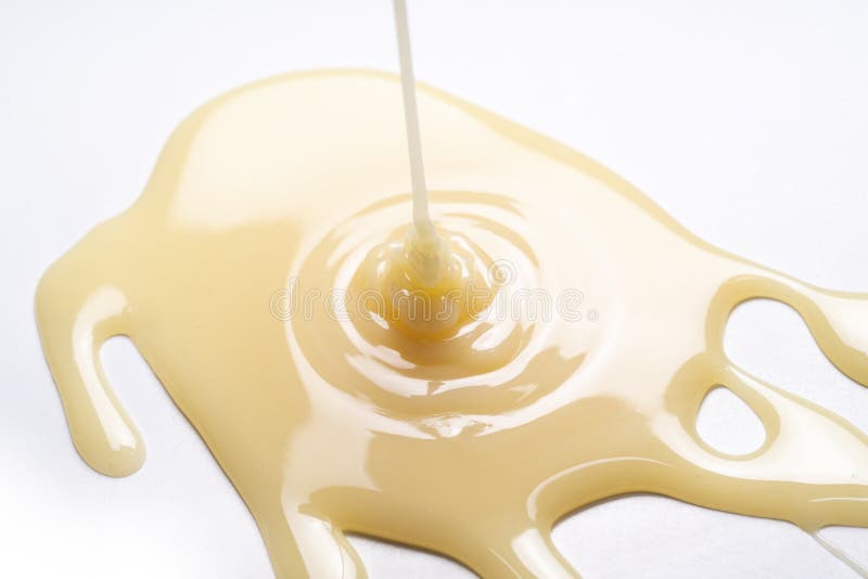 Drips of Condensed Milk on a Chocolate Brown Background Stock Photo ...