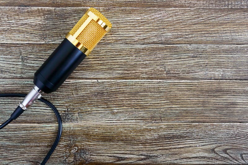 Condenser Gold Microphone with Cable on a Wooden Table with Copy Space ...