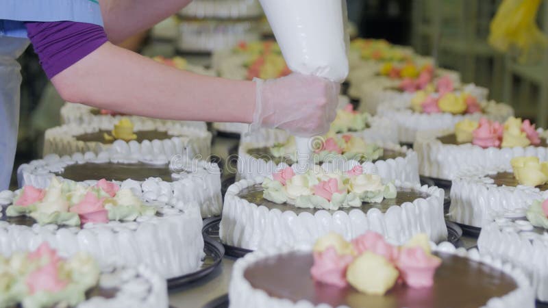Decorating Cake at the Bakery. Worker Decorating Cakes Using Cream in ...