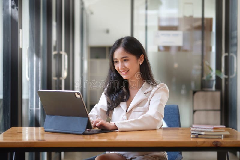 Confident Asian Business Woman Using Computer Tablet while Sitting in Bright Modern Office Stock ...