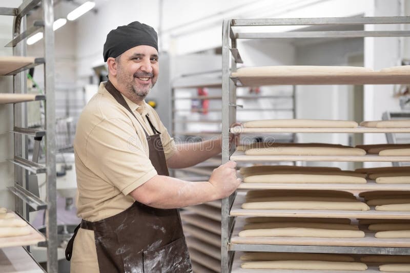 Confident Baker Posing with Rack of Fresh Bread Loaf at Bakery. Stock ...