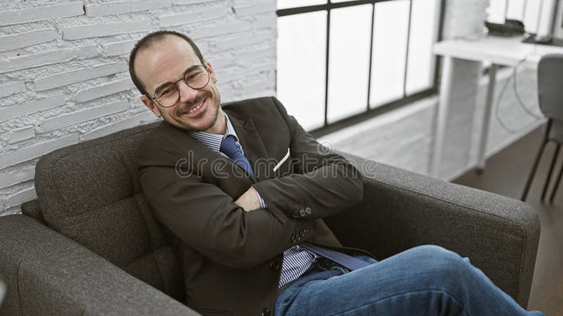 Confident Bald Man with Beard in Suit Sitting on Couch in Modern Office ...