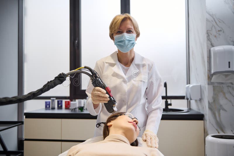 Confident Dermatologist Doctor Performs Cosmetic Procedures On A Woman