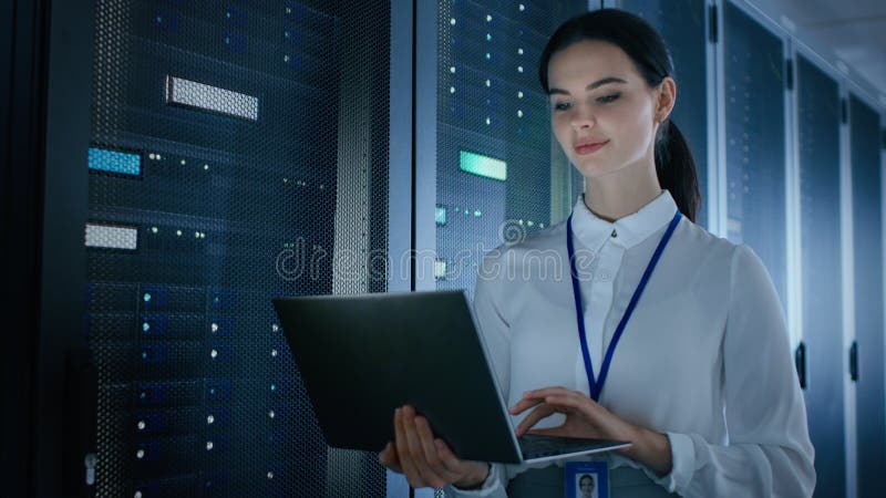 Confident and Beautiful Female it Engineer is Working on Laptop in Data ...