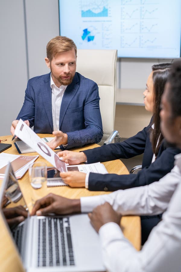 Confident Businessman Looking at One of Two Colleagues during ...