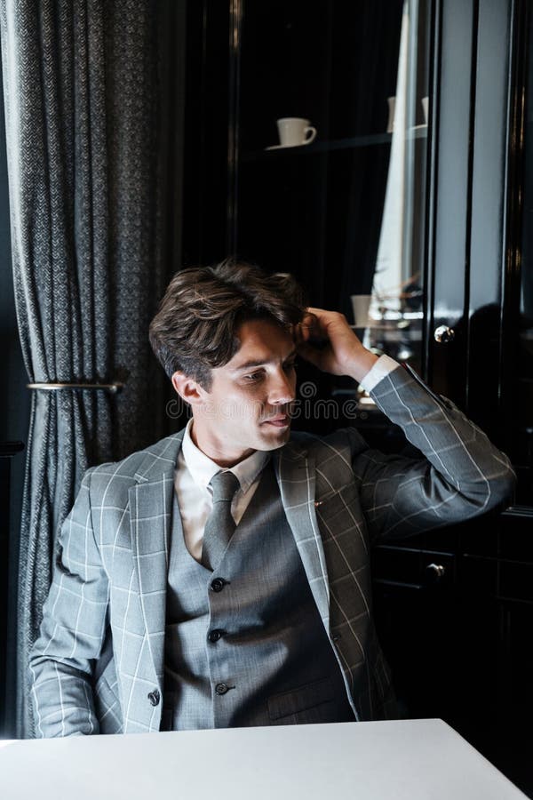 Confident Businessman in Suit Posing while Sitting at the Table Stock ...