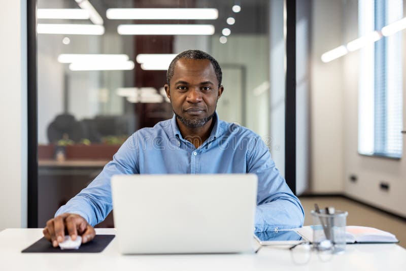 Confident Businessman Working on Laptop in Modern Office Environment at ...