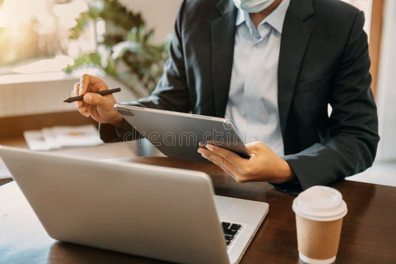 Confident Businessman Working on Laptop and Tablet at Her Workplace at ...