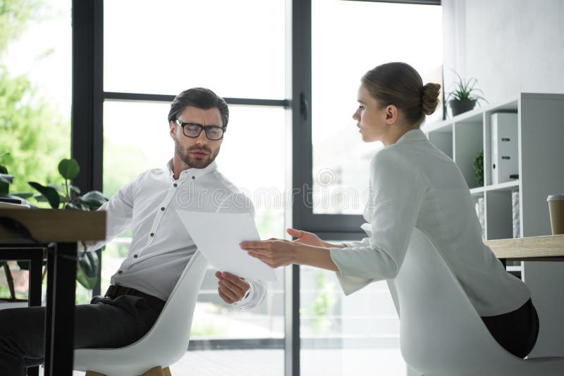 Confident Businesspeople Passing Documents at Workplace Stock Image ...