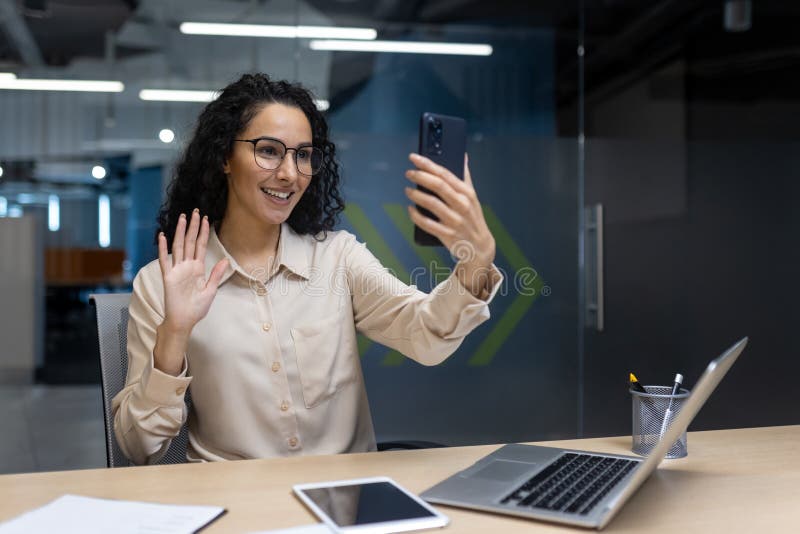 Businesswoman Waving during Video Call in Modern Office Environment ...