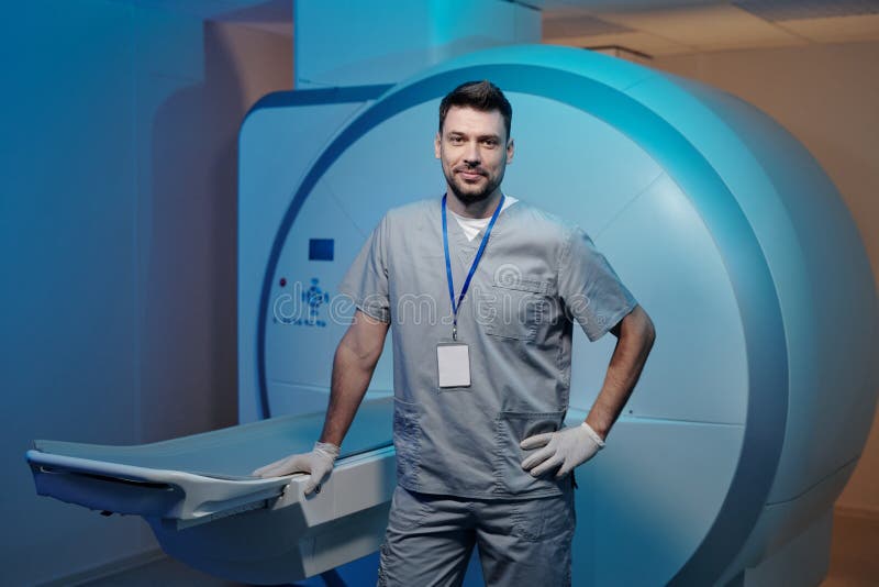 Confident Clinician in Grey Uniform Standing by Table of Mri Scan ...
