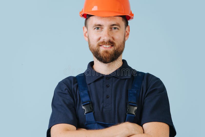 Confident Construction Worker in a Orange Helmet and Blue Uniform ...