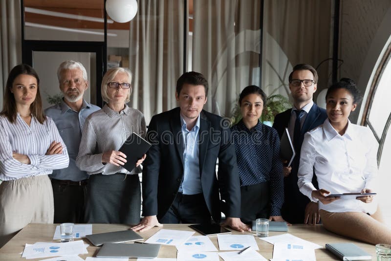 Confident Diverse Employees of Different Age Standing at Meeting Table ...
