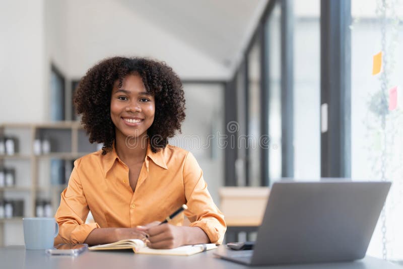 Confident Ethnic Businesswoman Using Laptop At Work Thinking And