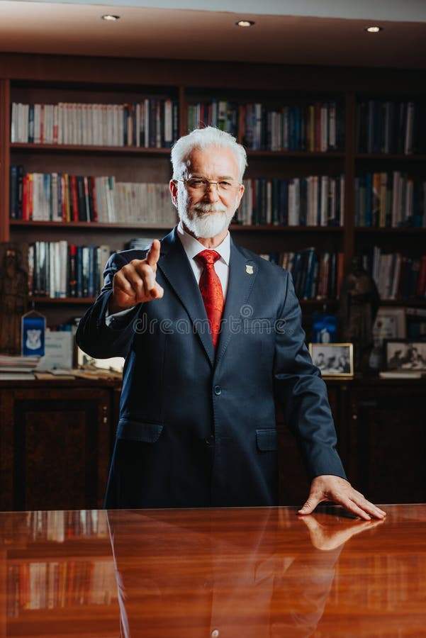 Confident, Experienced Rector Posing in a University Library Surrounded ...