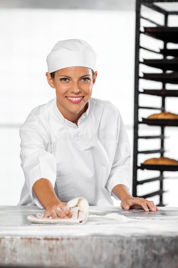 Confident Female Baker Cleaning Flour from Table Stock Image - Image of ...