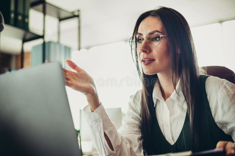Confident Female Professional in Elegant Work Attire Gestures during a ...