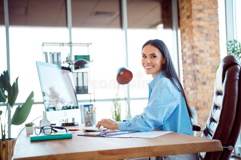 Professional Woman Smiling at Desk in Modern Office Setting with ...