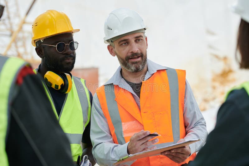 Confident Foreman with Document and Pen Explaining Something To ...