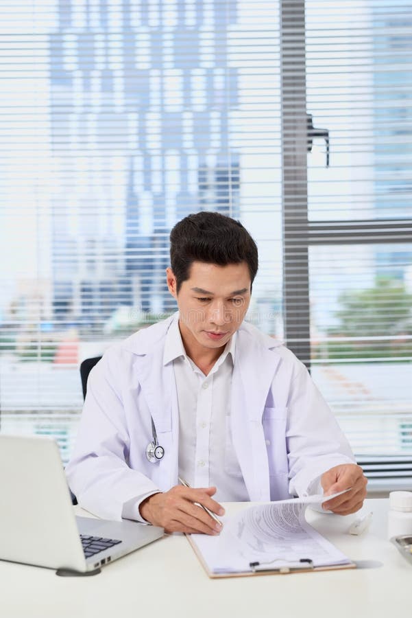 Confident Male Doctor with Stethoscope Working in Office Stock Photo ...