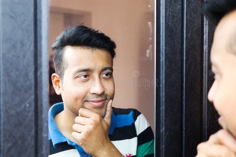 A Man Looking at His Reflection in Mirror and Laughing at Himself Stock ...