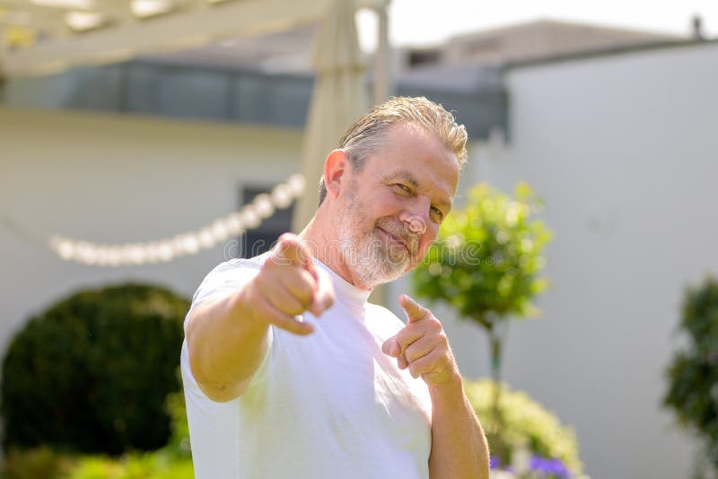Confident Man Pointing Playfully Stock Photo - Image of garden, mature ...