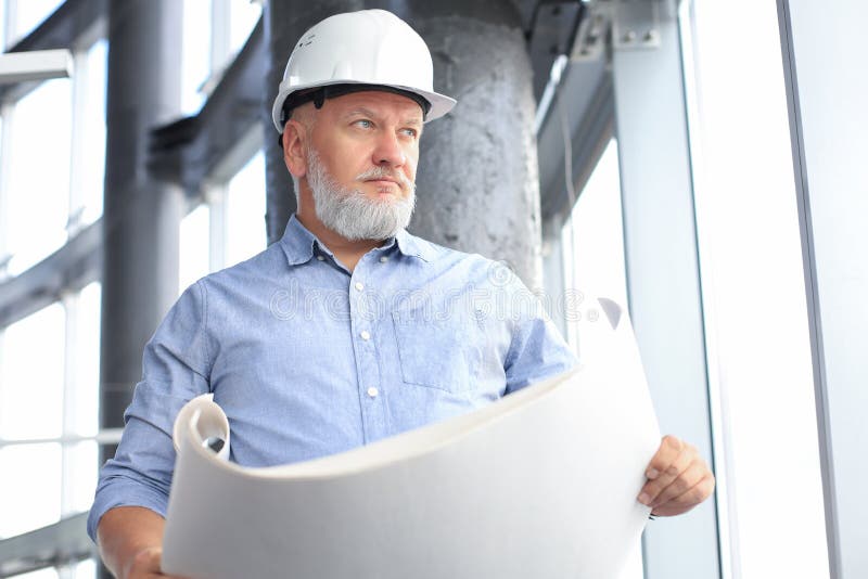 Confident Mature Architect in Corporate Suit and Hardhat Holding a ... Confident Mature Architect in Corporate Suit and Hardhat Holding a ...
