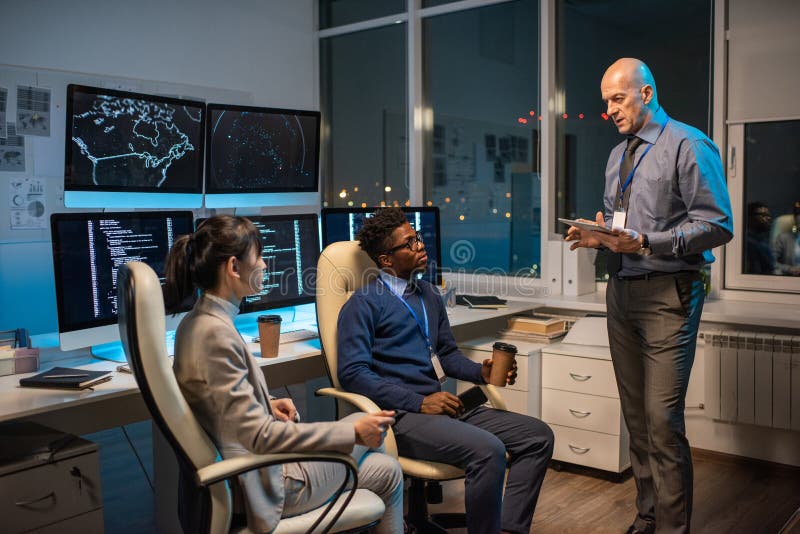 Confident Mature Manager with Tablet Interacting with Two Young ...
