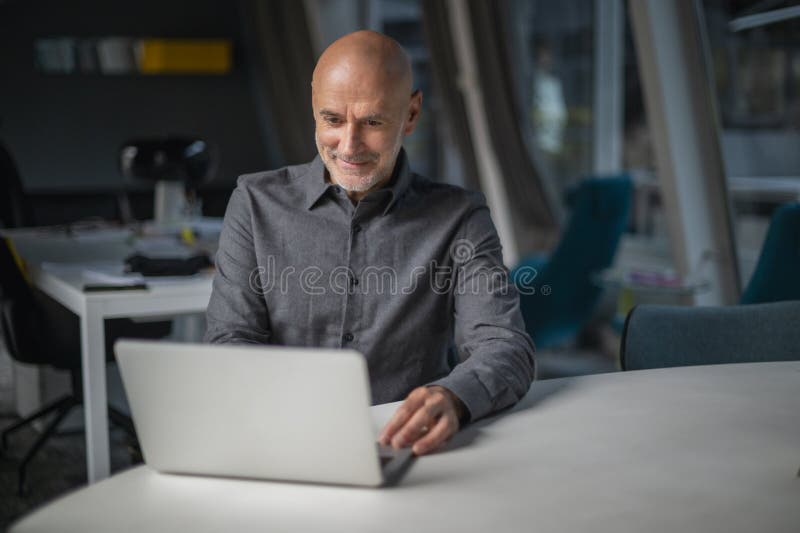 Confident Middle Aged Businessman Sitting at the Office and Using ...