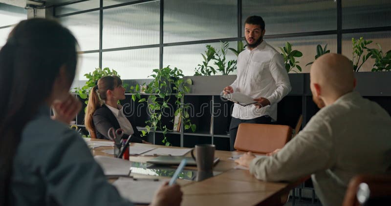 A Confident Office Worker Explains His Idea Pointing To a Chart while ...