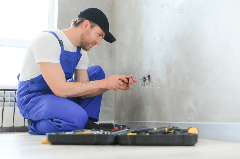 Confident Professional Electrician in Uniform Using Screwdriver while ...