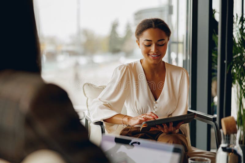 A Confident Professional Engaged in Work on a Tablet within a ...