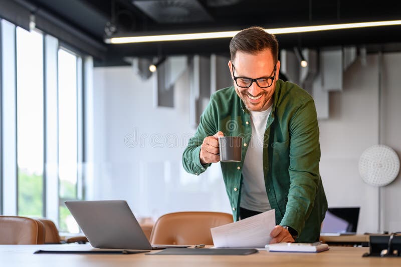 Confident Project Manager Holding Coffee Cup and Reading Reports on ...