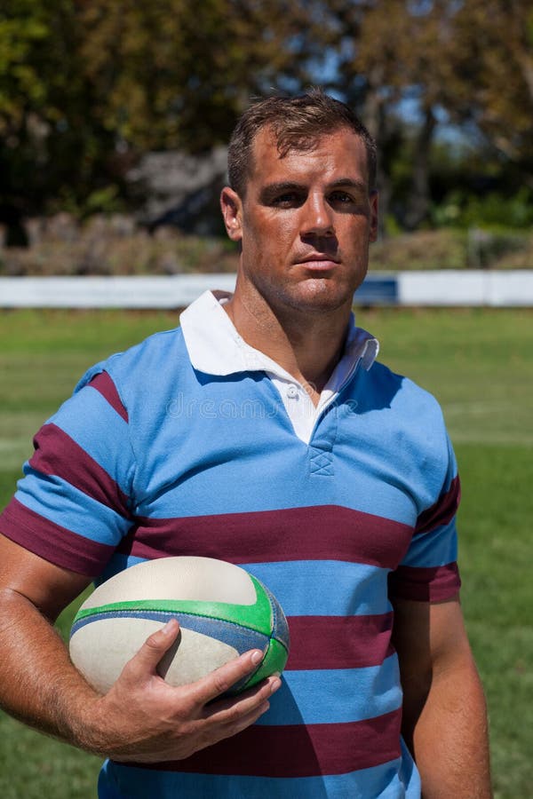 Confident Rugby Player Holding Ball at Field Stock Photo - Image of ...