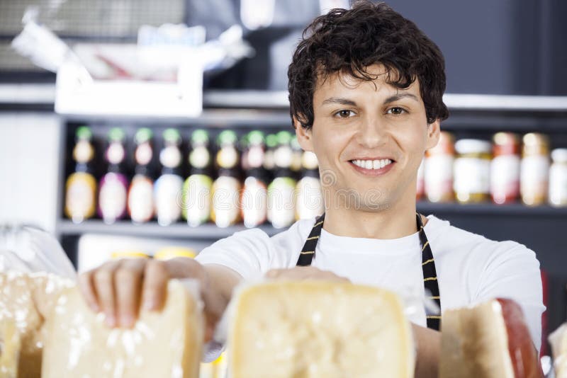 Confident Salesman Arranging Cheese in Shop Stock Photo - Image of ...
