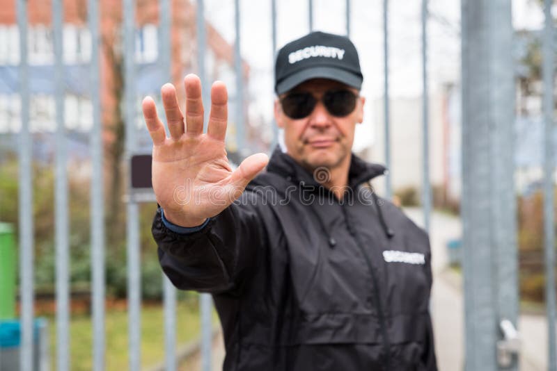 Security Guard Making Stop Gesture in Front of Gate Stock Image - Image ...