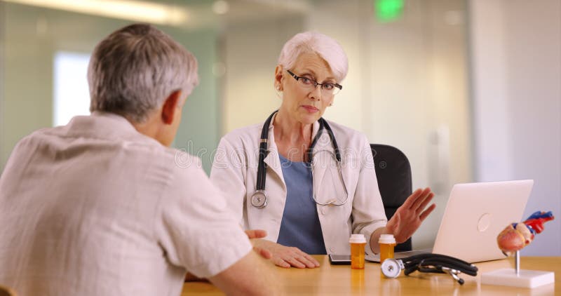 Confident Senior Doctor Talking with Elderly Man in the Office Stock ...