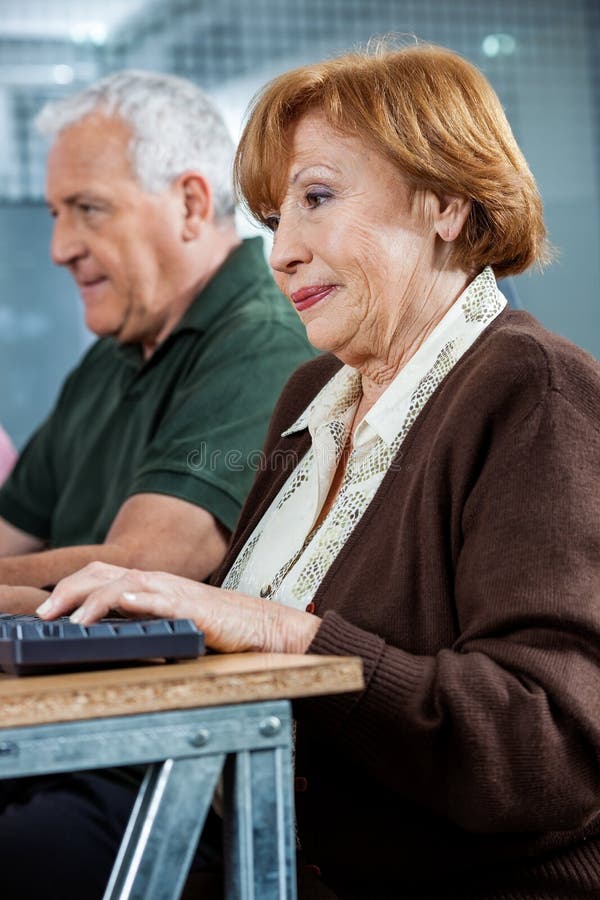Confident Senior Students Using Computer in Classroom Stock Image ...