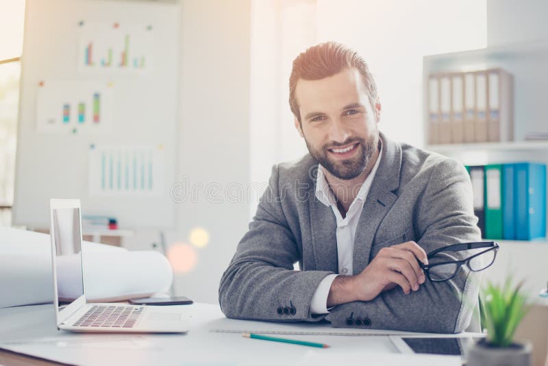 Confident Smiling Architect in Formal Wear Holds Glasses and Si Stock ... Confident Smiling Architect in Formal Wear Holds Glasses and Si Stock ...