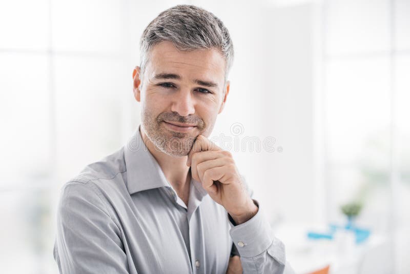 Confident Smiling Man Posing in the Office and Smiling at Camera Stock ...