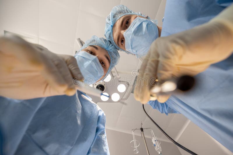 Confident Surgeons Looking Down at Camera while Operating Stock Photo ...