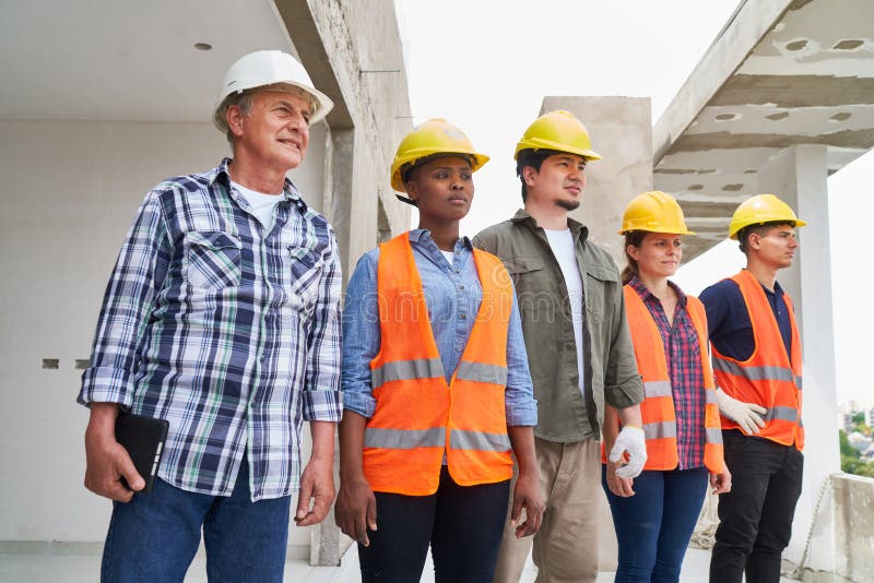 Confident Team of Construction Workers in Workwear Looking Away while ...