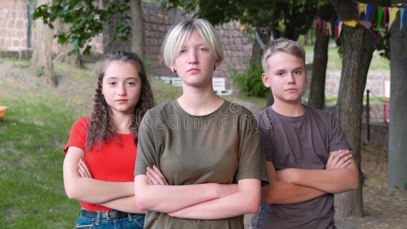 Confident Teenagers Standing Outdoors with Arms Crossed, Expressing ...
