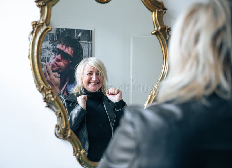 Confident Woman Smiling in Mirror with Iconic Poster Reflection Stock ...