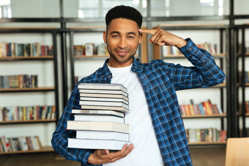 Confident Young African Male Student Holding Stack of Books Stock Photo ...