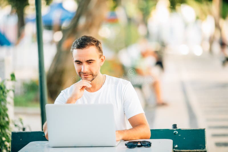 Confident Young Stylish Man Working on Laptop Computer while Sitting ...