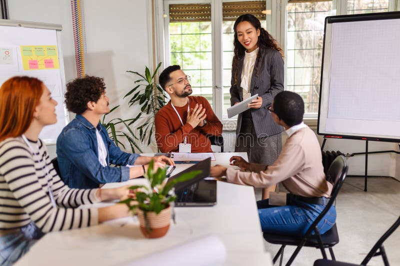 Young Team Leader Giving a Presentation To a Group of Young Colleagues ...