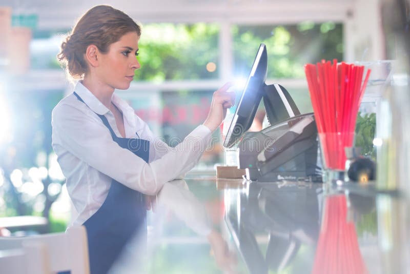Side View of Confident Young Waitress Using Computer while Standing at ...