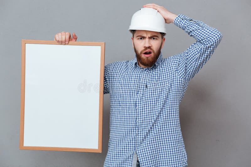 Confused Builder in Helmet Scratching His Head and Holding Tablet Stock ...