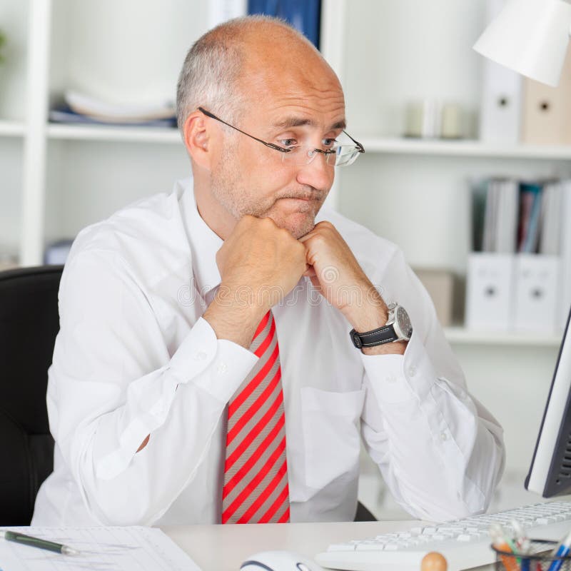 Confused Businessman Staring at Computer at Office Desk Stock Photo ...